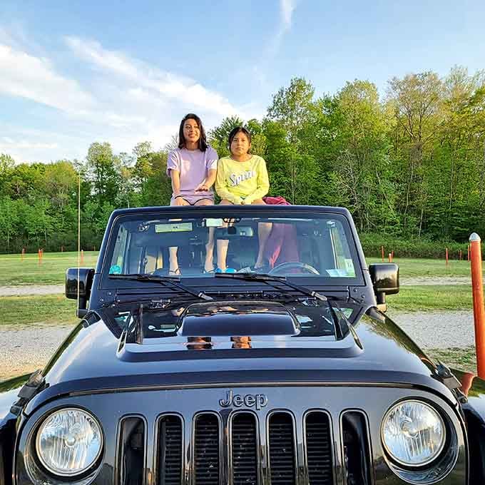 Kids perched on the Jeep like it's their own private viewing tower&mdash;pure childhood joy captured perfectly.