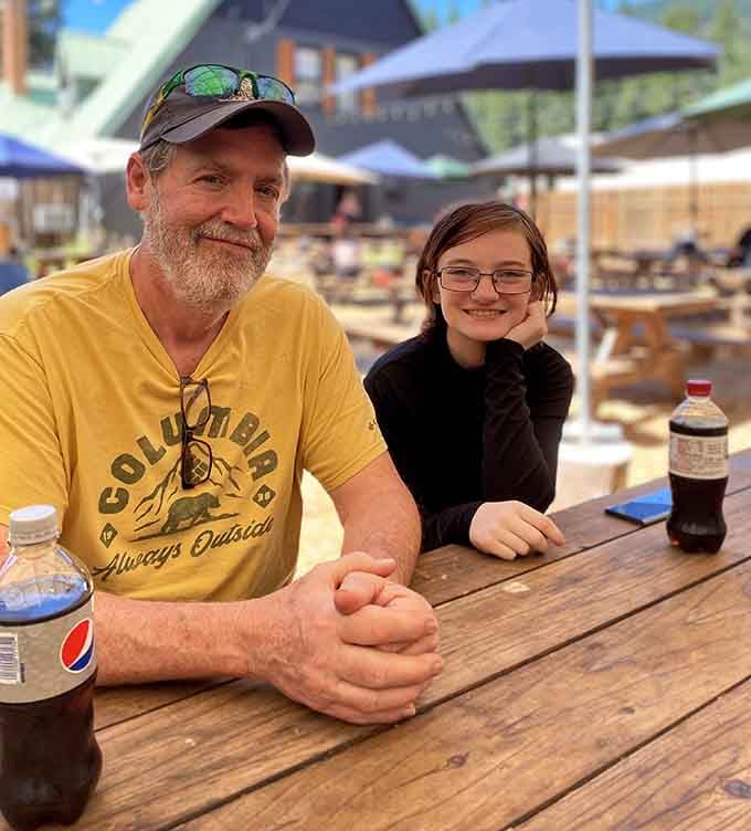 Happy diners at outdoor picnic tables enjoying their meals, which is basically the universal sign of a place doing things right.
