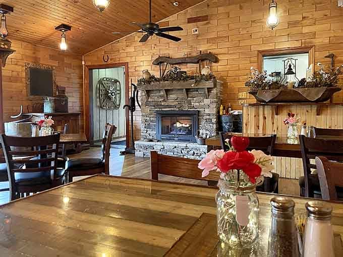 That stone fireplace anchors a dining room where rustic charm meets genuine warmth in every thoughtful detail.