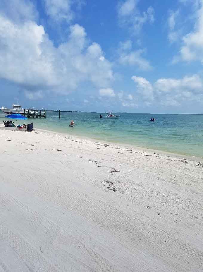 Families wade in shallow, calm waters where the biggest danger is stepping on a shell you wanted to collect.