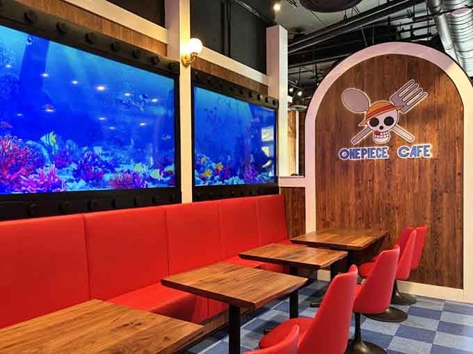 Red vinyl booths facing tropical aquarium screens create the perfect spot for plotting your next grand adventure together.