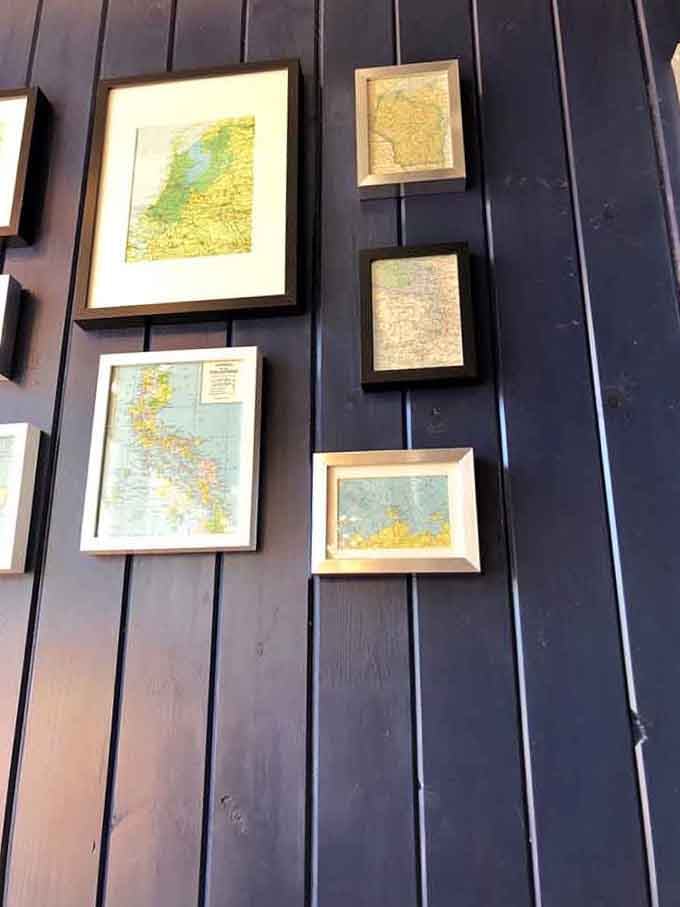 Vintage map art on dark wood paneling adds character and wanderlust to your breakfast, inspiring adventures between bites of toast.