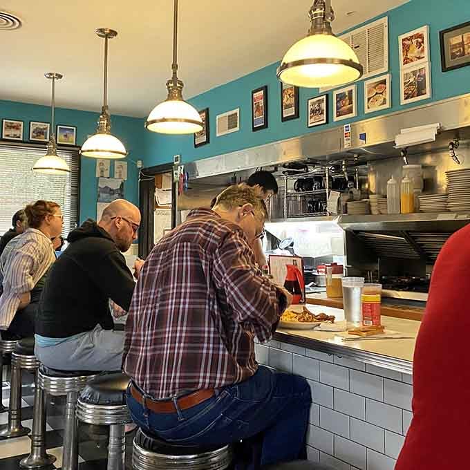 Counter seating where strangers become friends over pancakes and the morning paper still exists in physical form here.