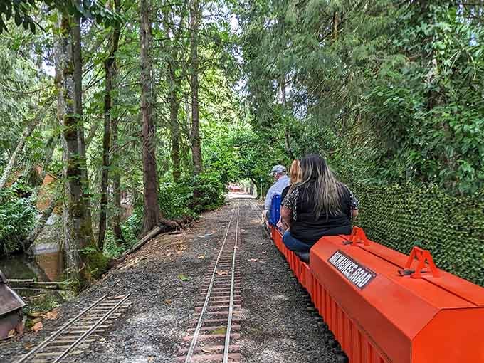 The tracks disappear into a tunnel of greenery, offering passengers a scenic journey through Oregon's natural beauty.