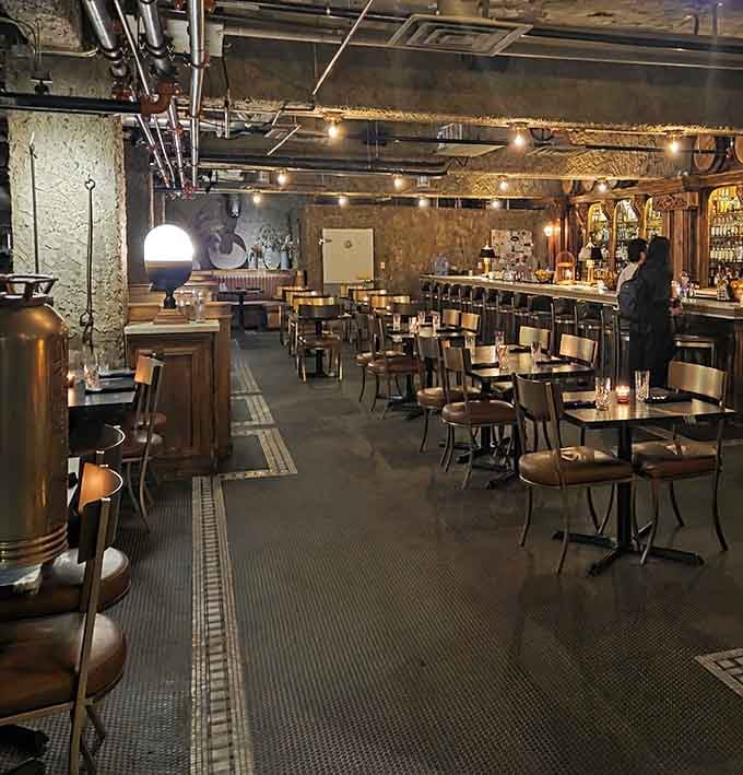 The exposed ceiling and vintage lighting prove that sometimes leaving things raw creates the most refined atmosphere.