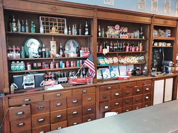 Wooden drawers and vintage bottles arranged like a museum exhibit dedicated to the golden age of soda fountains.