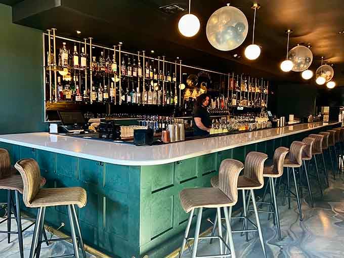 The bar beckons with polished surfaces and perfectly arranged bottles, inviting you to start your evening right.