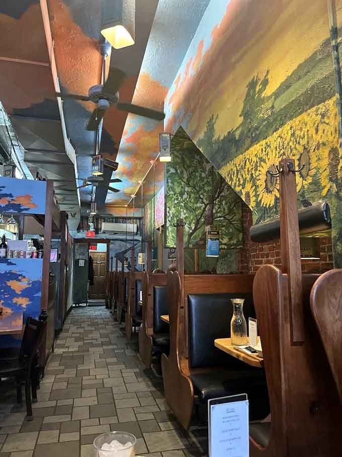 Exposed brick meets colorful murals in a dining space that feels both rustic and whimsically artistic simultaneously.