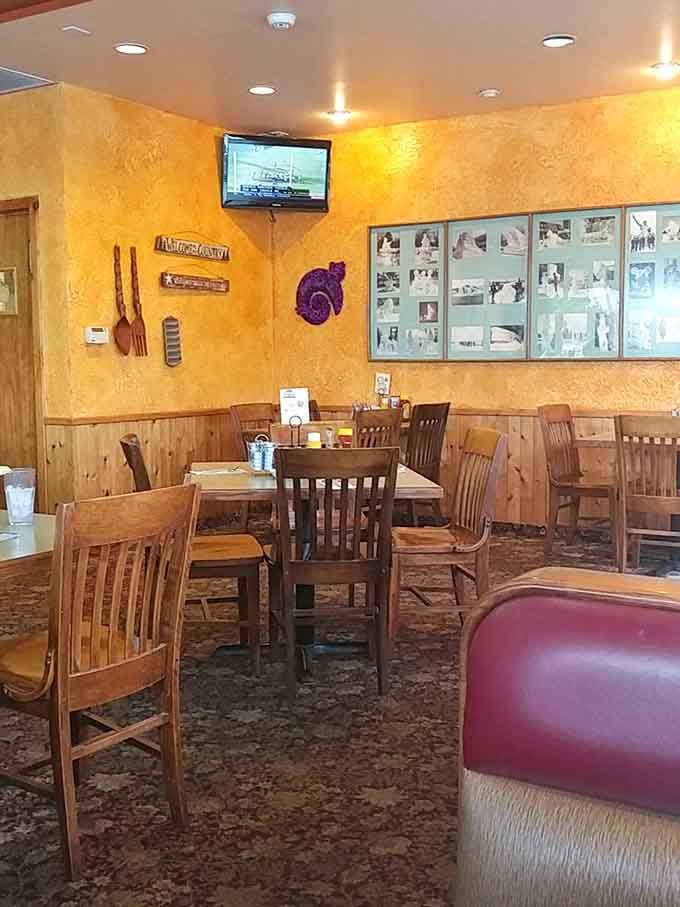 Bright yellow walls and framed photos create a cheerful dining room where strangers become regulars over shared meals.