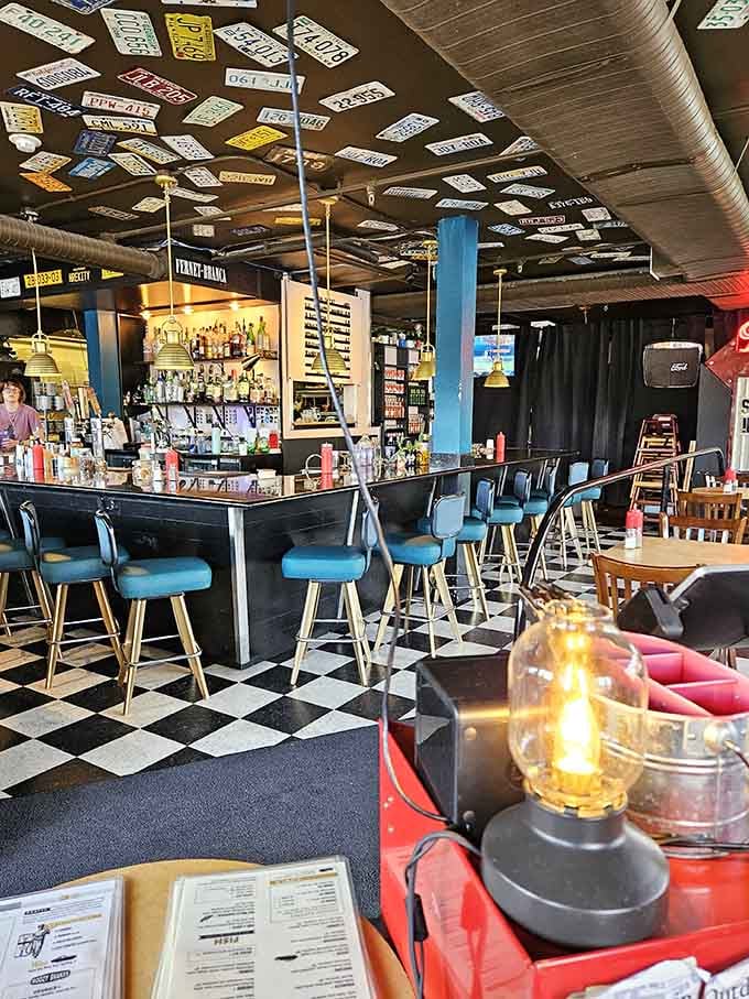 Blue bar stools and black checkerboard floors create a retro vibe that makes every meal feel like a special occasion.