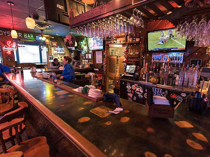 The bar area buzzes with energy, where cold drinks and warm hospitality meet under vintage nautical decor.