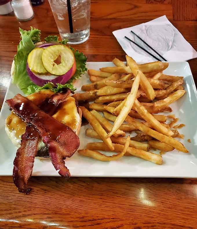 A burger topped with bacon and pineapple that arrives with enough fries to feed a small army or one very hungry person.