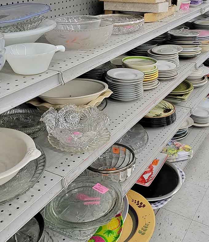 Kitchenware stacked neatly, from vintage serving dishes to modern plates that survived their previous owners' dinner parties.