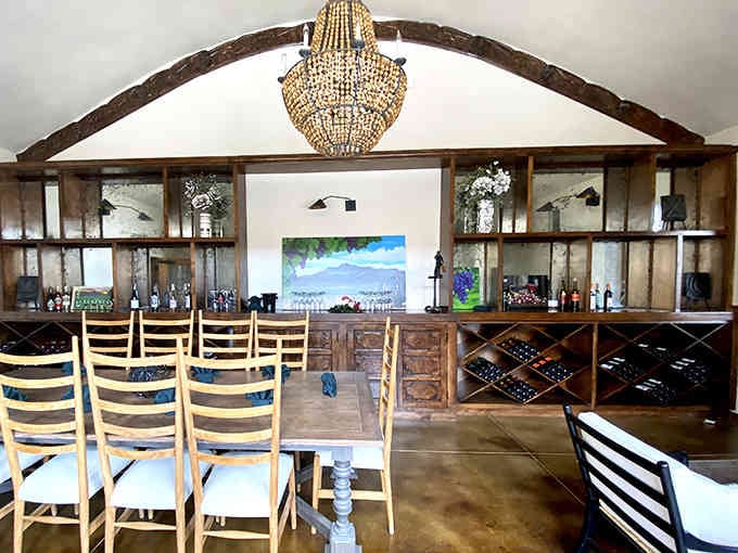 Exposed beams, a sparkling chandelier, and wine storage that doubles as decor create farmhouse elegance done right.