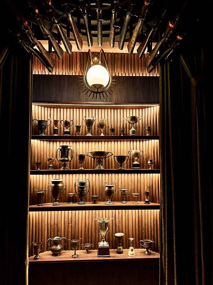 Trophy cases display vintage cups and awards, making you wonder what victories they celebrated before becoming part of this story.