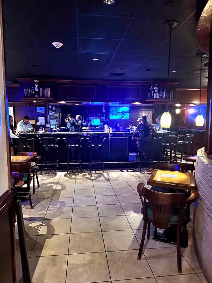 The bar glows with blue ambiance, perfect for pre-dinner cocktails or post-steak celebration drinks with friends.