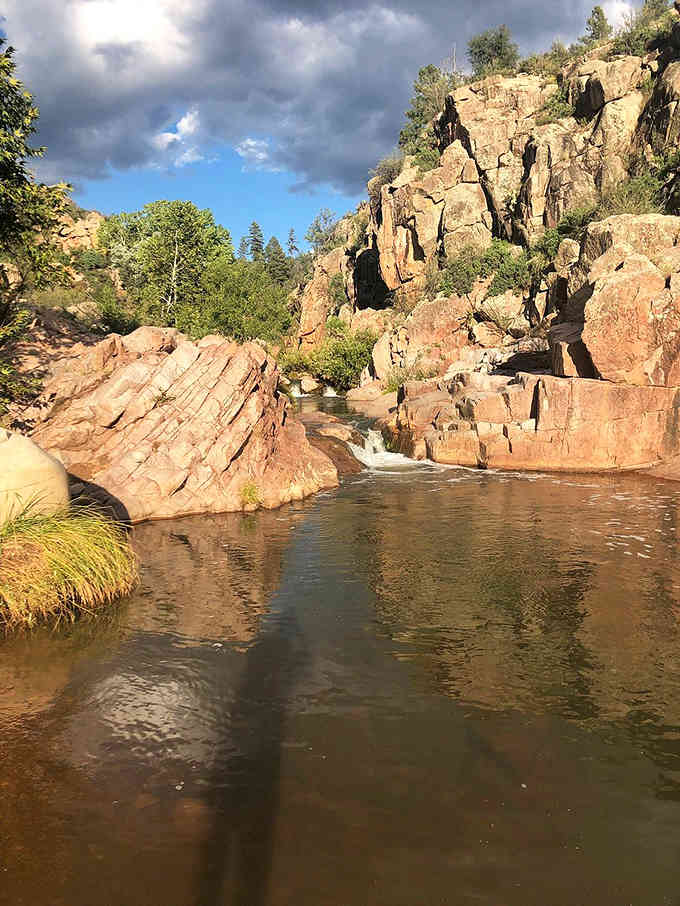 Smooth rock and still water create a mirror finish, the kind of view that makes cameras seem inadequate.