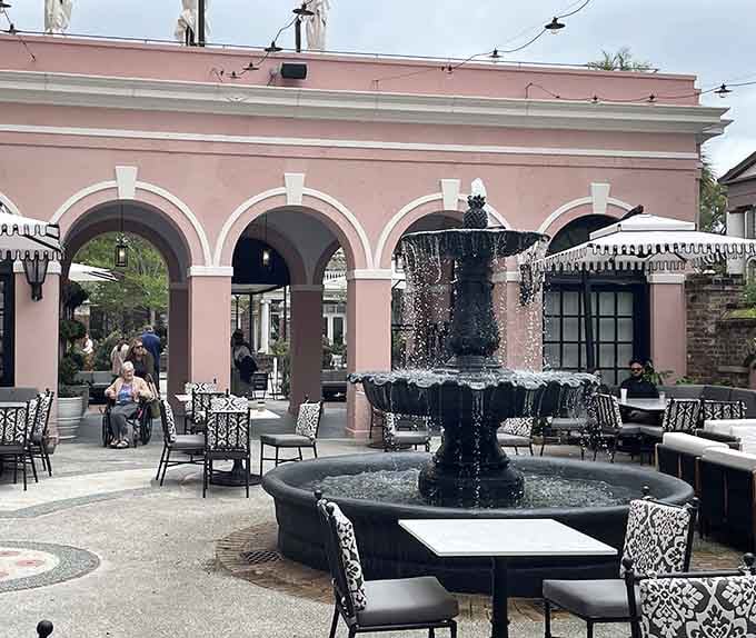 The graceful fountain centerpiece creates a European courtyard atmosphere where pink arches frame tables set for memorable meals and celebrations.