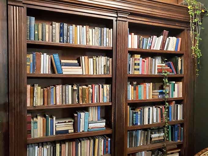 Real books line these shelves, adding authenticity to the speakeasy theme without crossing into theme park territory.