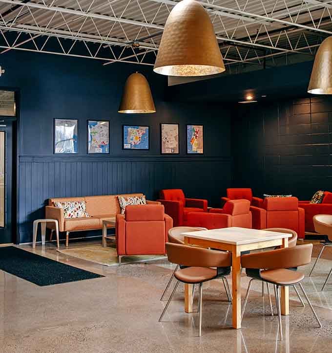 Orange chairs pop against dark walls in a lounge area that's equally perfect for dates or catching up.