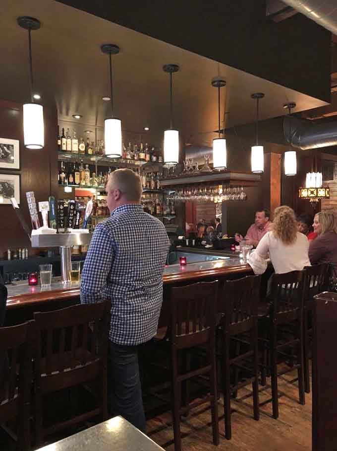 The bar where solo diners become regulars and strangers become friends over shared plates and good conversation.