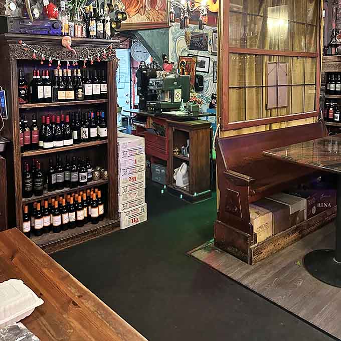 Wine bottles line vintage shelving creating a display that's equal parts functional bar and curated art installation.