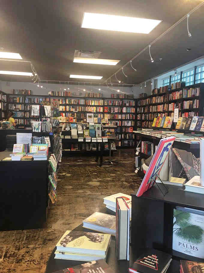 Dark shelves against light walls create a sophisticated backdrop for thousands of stories waiting to be discovered and loved.