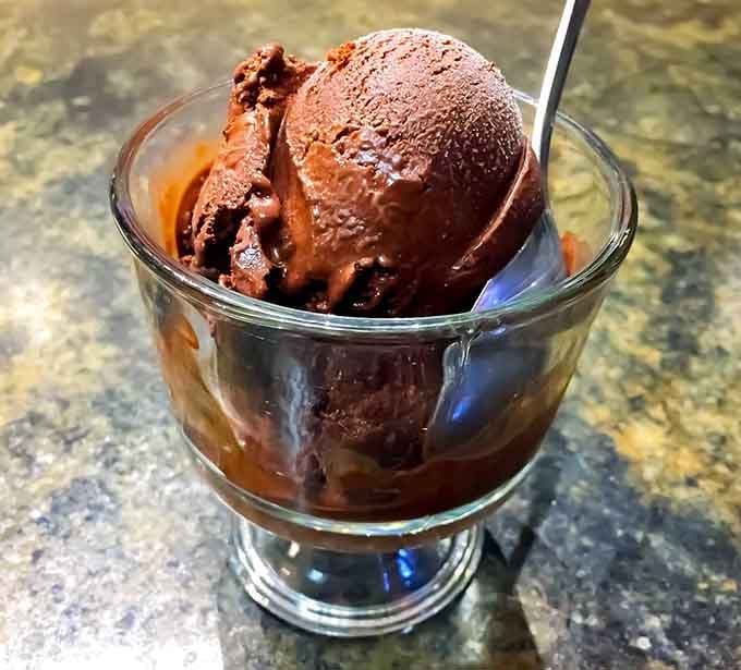 Rich chocolate ice cream scooped into a classic sundae glass, proving simple pleasures are often the best ones.