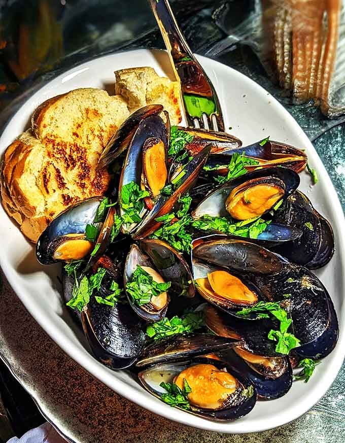 Perfectly steamed mussels with crusty bread for soaking up every last drop of that incredible broth, pure Belgian bliss.