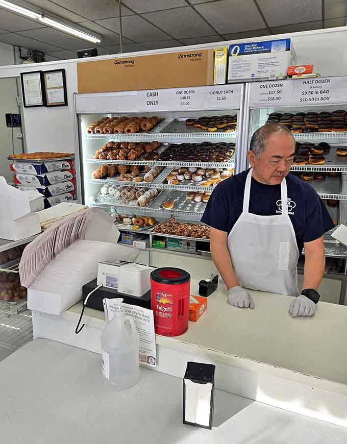 Efficient service behind the counter keeps the morning rush moving, boxing up happiness one dozen at a time for grateful customers.