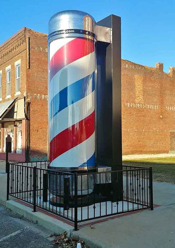 The spiraling barber pole reaches skyward, advertising haircuts for giants or just celebrating small-town American tradition magnificently.