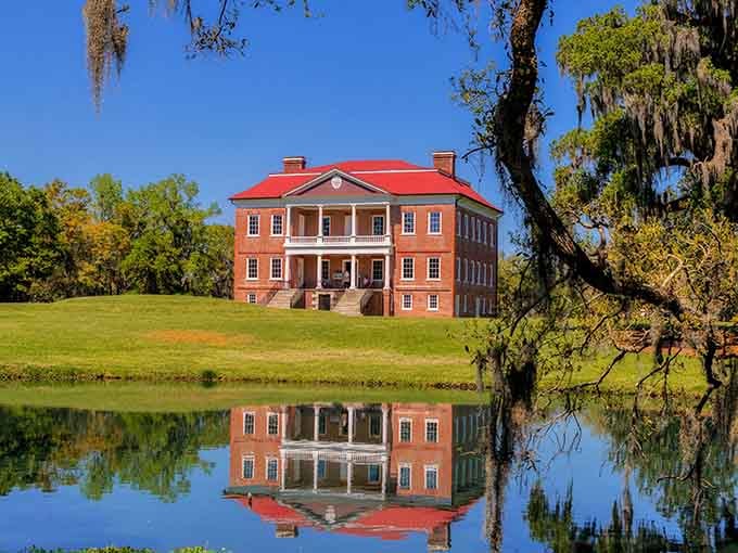 Drayton Hall's brick Georgian elegance reflects across still waters, creating a mirror image of architectural perfection.