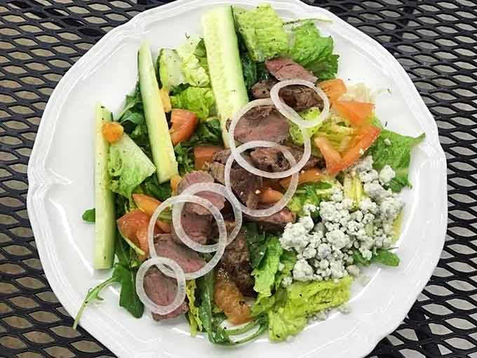 Fresh greens topped with tender steak, blue cheese, and crisp vegetables prove even salads get serious treatment here.