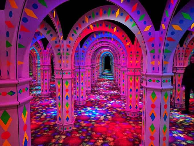 Purple and pink lights wash over the mirrored surfaces, creating an otherworldly atmosphere that's pure magic.