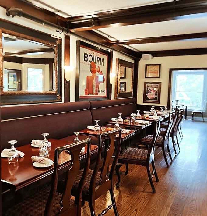 Vintage posters and rich wood create a sophisticated dining space that feels both timeless and welcoming to everyone.