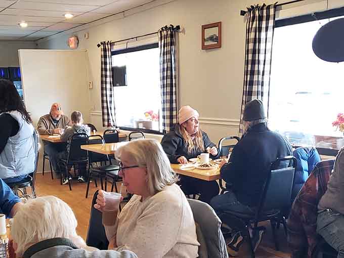 Natural light streaming through checkered curtains onto happy diners&mdash;proof that ambiance doesn't require a big budget or pretension.