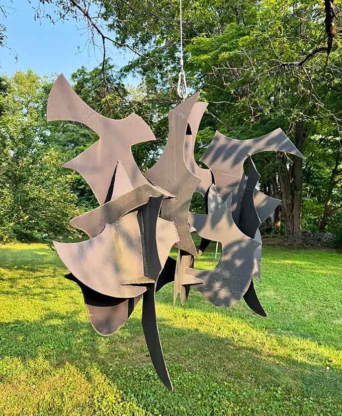 Enjoy the gentle, artistic movement of this hanging sculpture, a beautiful and calming addition to the serene woodland surroundings today.