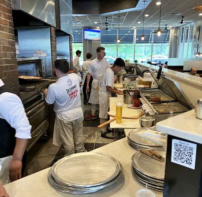 Watch the team work their magic, stretching dough and building pies with practiced precision and care.