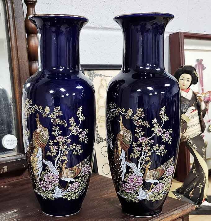 Ornate navy vases with golden peacock designs that would make any mantelpiece infinitely more interesting.
