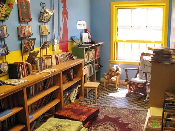 Bright yellow window frames and playful wall art transform the children's section into pure imagination territory.