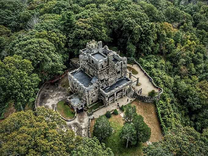 From above, the castle's asymmetrical design reveals itself, a stone puzzle piece nestled perfectly into the forested hillside.
