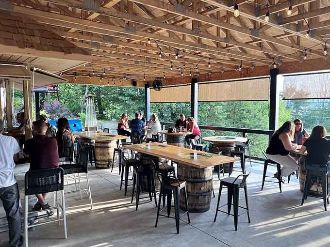 The covered patio features barrel tables and string lights, creating that perfect casual-fancy vibe for outdoor dining.