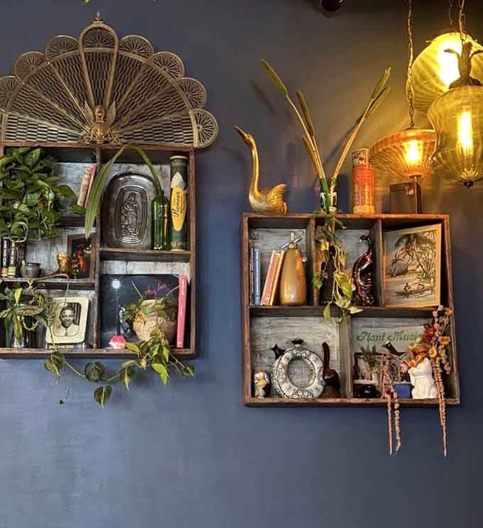 Wall shelves displaying eclectic treasures create a curated chaos that somehow makes perfect visual sense.
