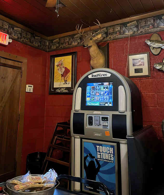 Even the jukebox gets the hunting lodge treatment, surrounded by mounted trophies and outdoor artwork.