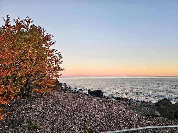 Sunset paints the pebbled shore in warm hues, turning an already beautiful beach into pure visual poetry.