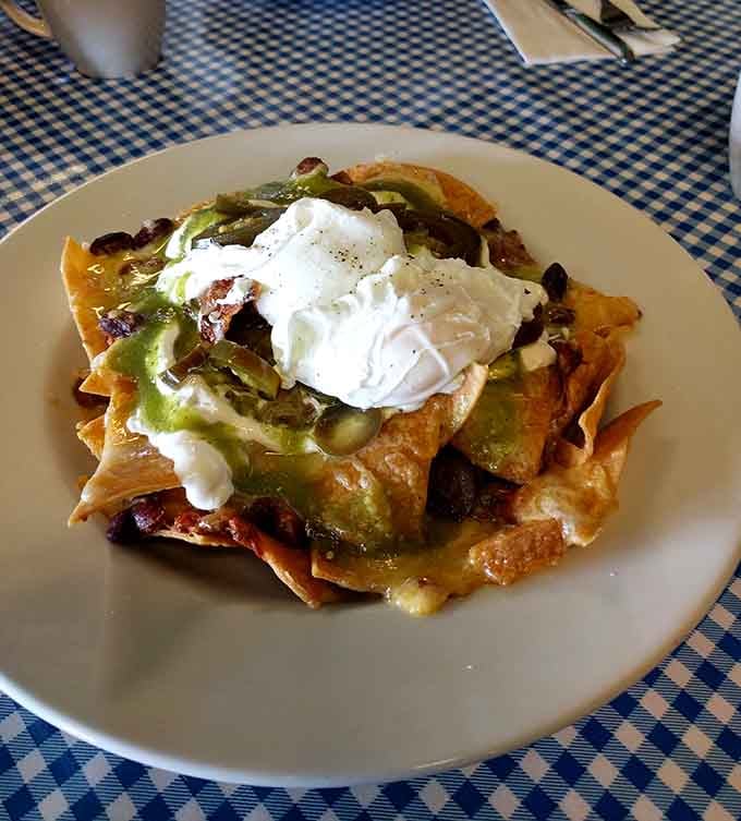 Nachos topped with what appears to be a poached egg, because why shouldn't breakfast and lunch have a delicious love child?