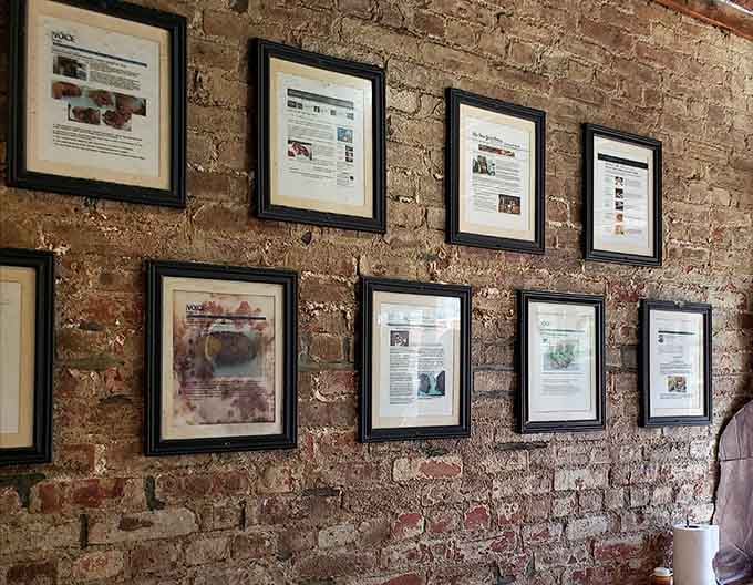 Framed press clippings on weathered brick tell the story of a barbecue joint that's earned its local reputation honestly.