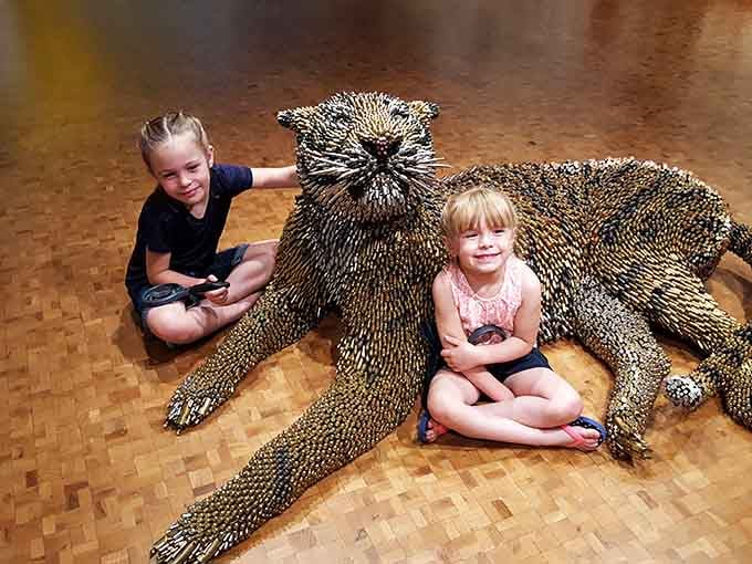Kids posing with a massive otter sculpture, proving this museum knows how to make art fun for everyone.