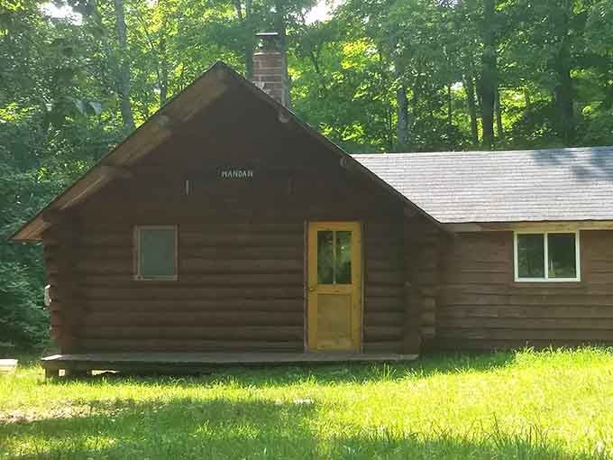 The cabin marked "Mandan" sits peacefully among trees, looking surprisingly content for a building that's outlived its entire reason for existing.