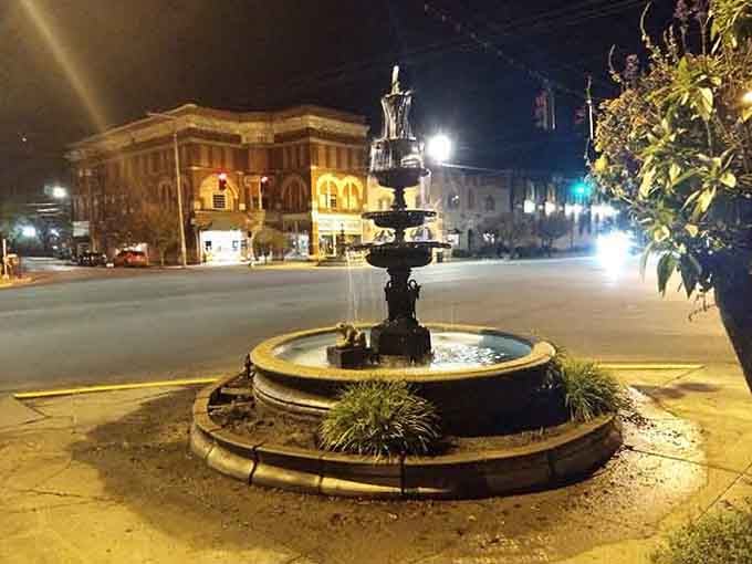 The town square fountain adds a touch of elegance to evening strolls, lit up like a small-town jewel.